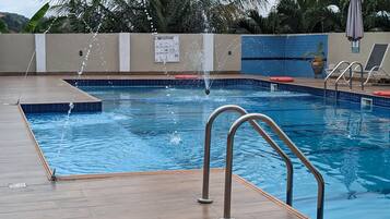 Piscina externa, guarda-sóis, salva-vidas no local