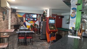 Um restaurante com mesa de bilhar, jukebox e árvore de Natal.