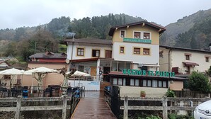 A building with a sign reading "HABITACIONES RESTAURANTE" and another sign "ATSDOR EL PUENTE".