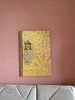 Paredes com arte abstrata geométrica e um banco abaixo.