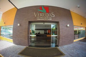 A entrada de Veredas do Rio Quente exibe um design moderno, com fachada curva e portas de vidro.