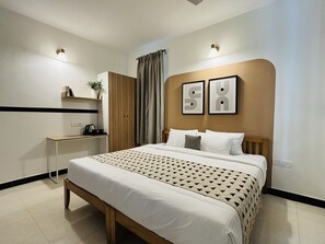 Quarto de hotel moderno com cama, mesa de cabeceira, guarda-roupa e duas luminárias fixadas na parede.