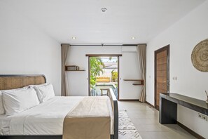 Quarto com cama, mesa de cabeceira, TV e vista para área externa com piscina e plantas.