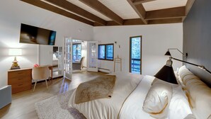Quarto com cama grande, escrivaninha, cadeira e guarda-roupa.