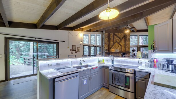 Cozinha moderna com eletrodomésticos de aço inoxidável, uma ilha grande e uma parede decorativa de pedra.