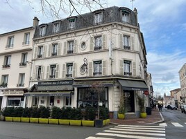 Um hotel com uma placa no andar térreo que diz "Hostellerie des 3 Marches" e "Auberge des Marchés".