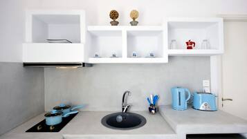 Uma cozinha moderna com pia embutida, chaleira, torradeira e cafeteira no balcão.