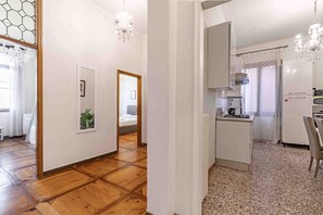 Interior moderno com piso de madeira, cozinha com fogão a gás e área de jantar com mesa e cadeiras.