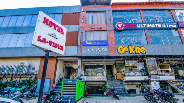 Um hotel chamado 'Hotel La Vista' com uma placa de 'Fab Hotels' e 'Go Kids' por perto.