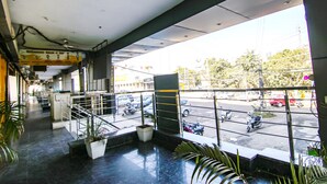 Um hall espaçoso com teto alto, escadaria e vista para a rua.