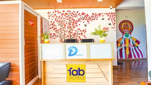 Uma receção com um logótipo, um sinal a indicar 'Sala de Convidados' e um mural colorido.