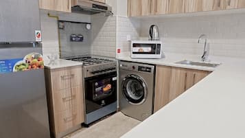 Apartamento luxo, 1 quarto | Cozinha privada | Geladeira grande, micro-ondas, fogão, chaleira elétrica