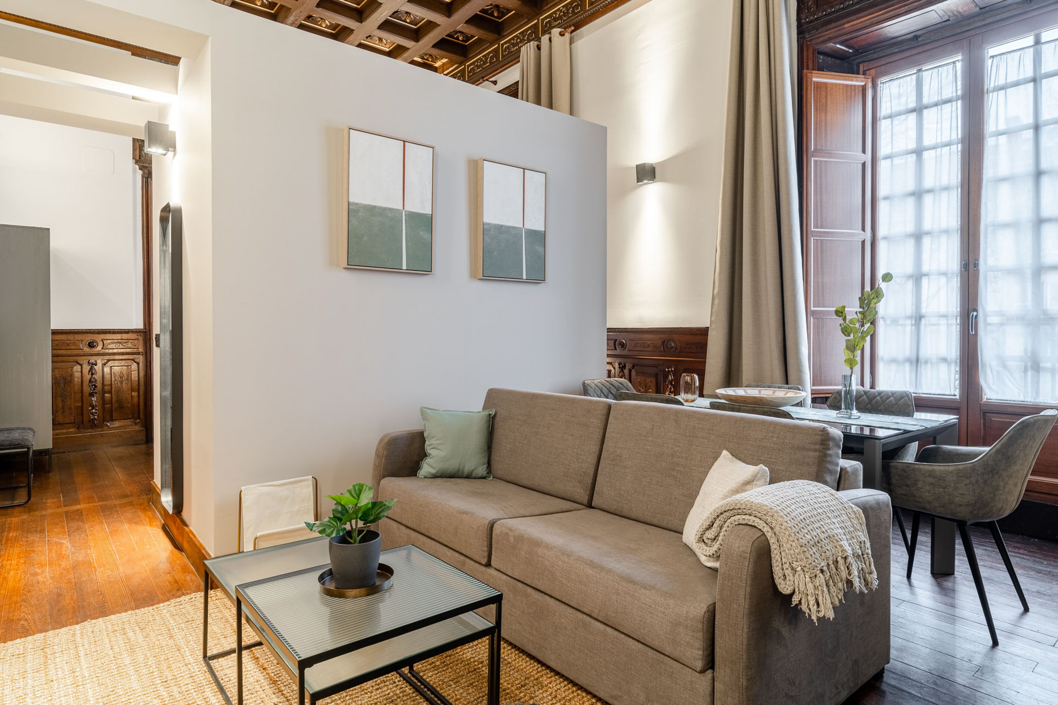 Uma sala de estar moderna com um sofá, uma mesa de centro e um espaço de jantar com uma mesa e cadeiras.