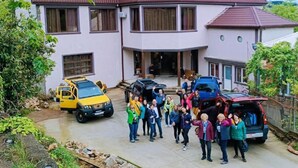 Uma casa grande, de vários andares, com telhado inclinado e entrada imponente.