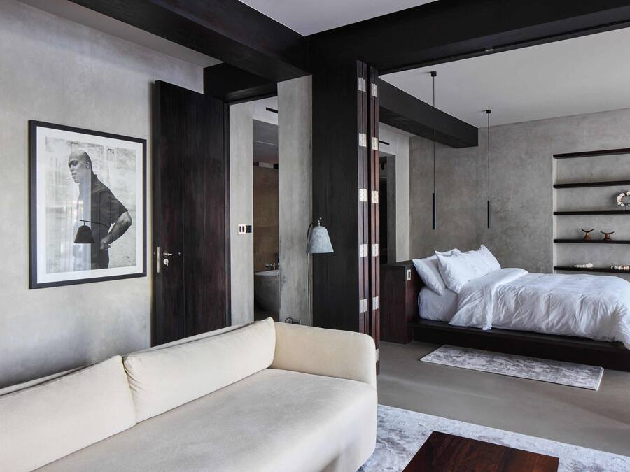 Quarto moderno com uma cama grande, um sofá e um quadro na parede.