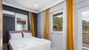 Quarto com cama, janela com cortinas e ar condicionado.