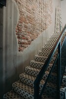 Uma escadaria com degraus estampados que levam até uma parede de tijolos.