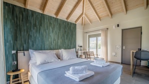 Quarto moderno com uma cama grande, uma escrivaninha e uma cadeira.