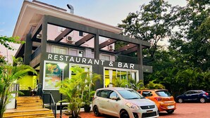Um restaurante e bar com design moderno, apresentando uma placa de destaque e uma escadaria que leva à entrada.