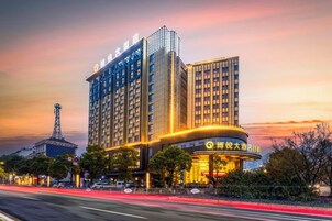 Um hotel imponente com entrada destacada e um grande letreiro.