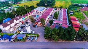 Vista aérea de uma área residencial com várias casas, um farol e um estacionamento.