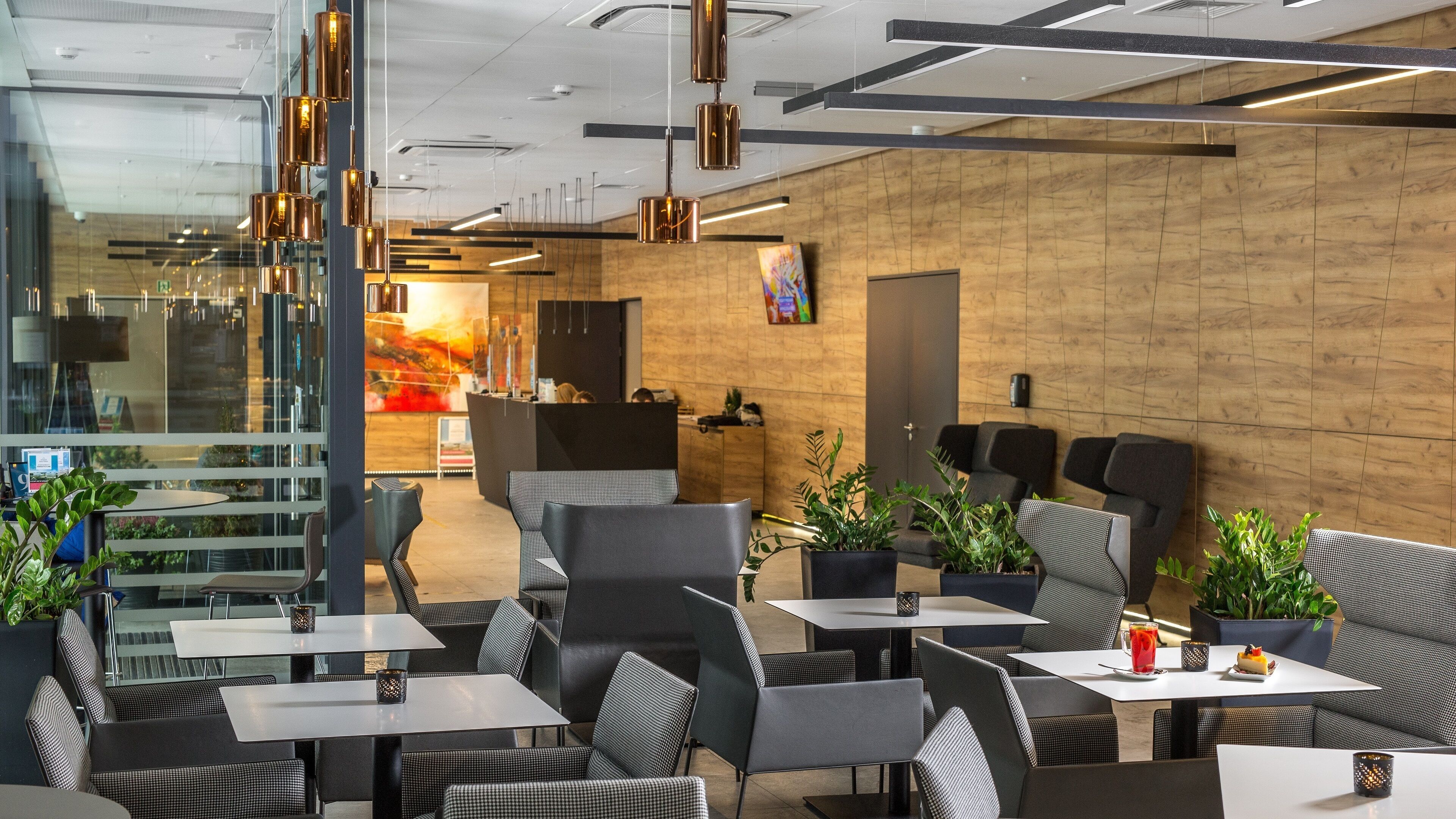 Um restaurante moderno com cadeiras, mesas e luminárias pendentes em padrão xadrez preto e branco.