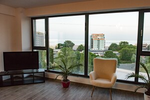 Apartamento panorâmico | Área de estar | Smart TV 80 cm com canais via satélite