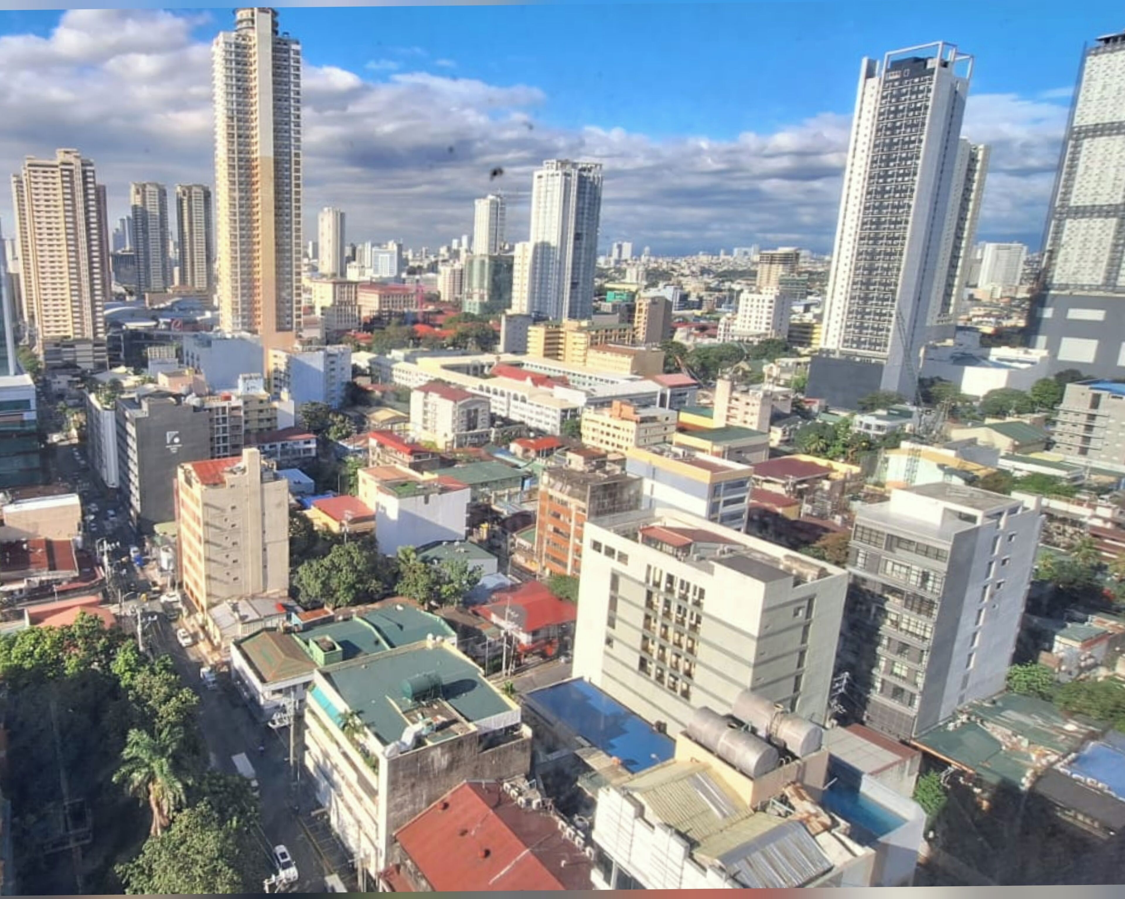 Paisagem urbana com arranha-céus, uma combinação de edifícios residenciais e comerciais, e um céu limpo.