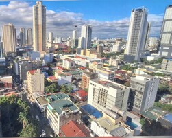 Paisagem urbana com arranha-céus, uma combinação de edifícios residenciais e comerciais, e um céu limpo.