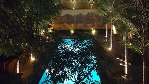 Resort com vários níveis, caminhos iluminados e piscina na base.