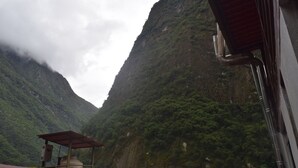 Paisagem montanhosa com um edifício de telhado vermelho e uma estrutura identificada como 'Rotoplasta'.