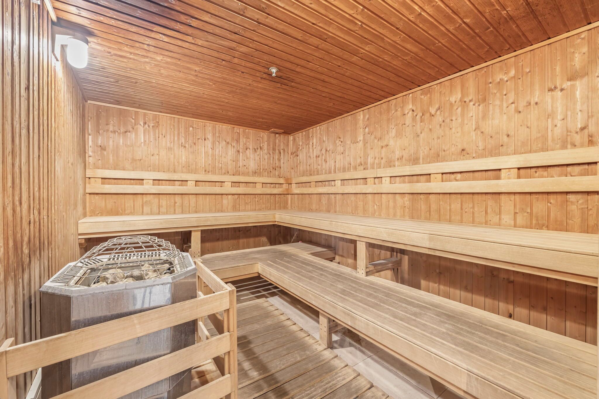 Uma sauna com bancos de madeira e unidade de aquecimento central.