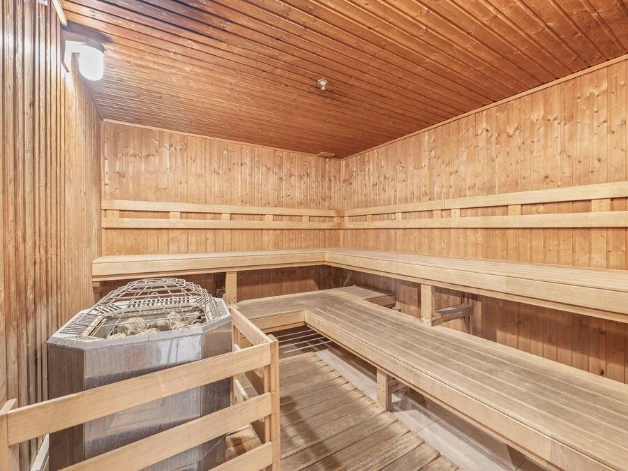 Uma sauna com bancos de madeira e unidade de aquecimento central.