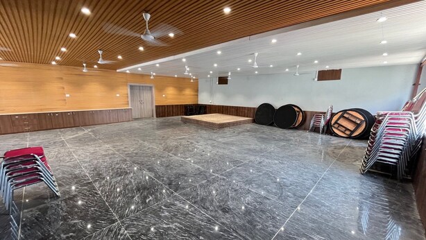 Um quarto amplo com piso de mármore polido, teto em painéis de madeira e iluminação embutida.