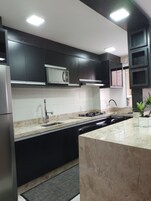Apartamento premium, acesso à piscina | Cozinha privada | Geladeira, micro-ondas, talheres/pratos/utensílios de cozinha