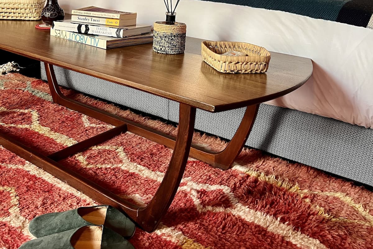 Quarto bem arrumado com cama, mesa de cabeceira e abajur.