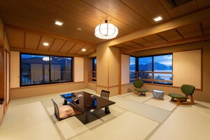 Um quarto japonês tradicional com tatames, uma mesa baixa e cadeiras verdes.