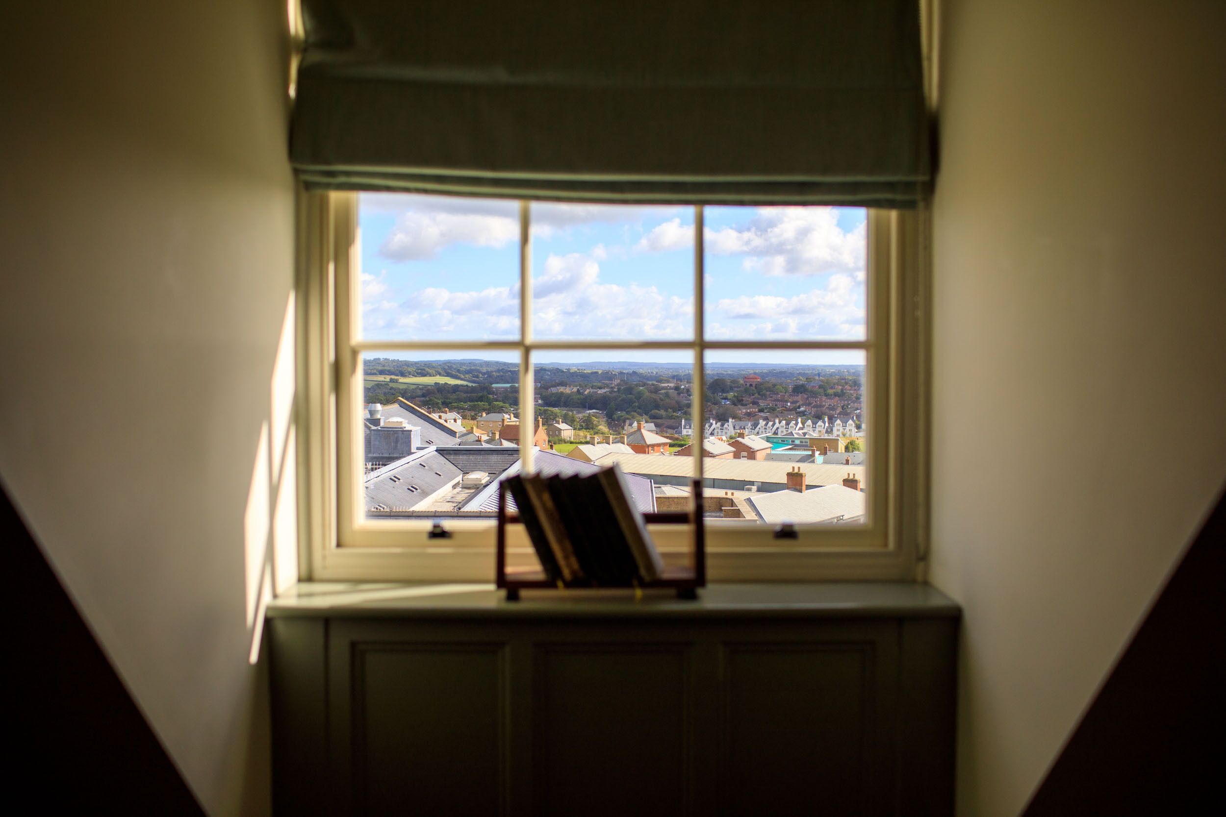 Janela com vista para uma área residencial, uma cadeira e um radiador.