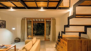 Uma sala de estar moderna com um sofá, um armário de madeira e uma escada.