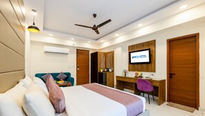 Quarto de hotel moderno com cama, escrivaninha e televisão.