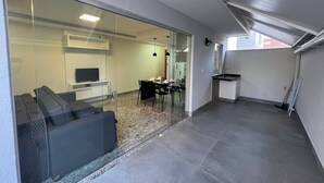 Um apartamento moderno com sala de estar, espaço para refeições e cozinha compacta.