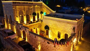 Um edifício histórico com sinalização iluminada com a inscrição 'SEYRI-İ ASUR KONAGI'.