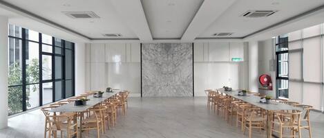 Uma sala de conferências ampla com uma mesa comprida e cadeiras, janelas grandes e uma parede de mármore.