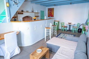 Uma sala de estar acolhedora com sofá, mesa de centro de madeira e canto de jantar com mesa e cadeiras.