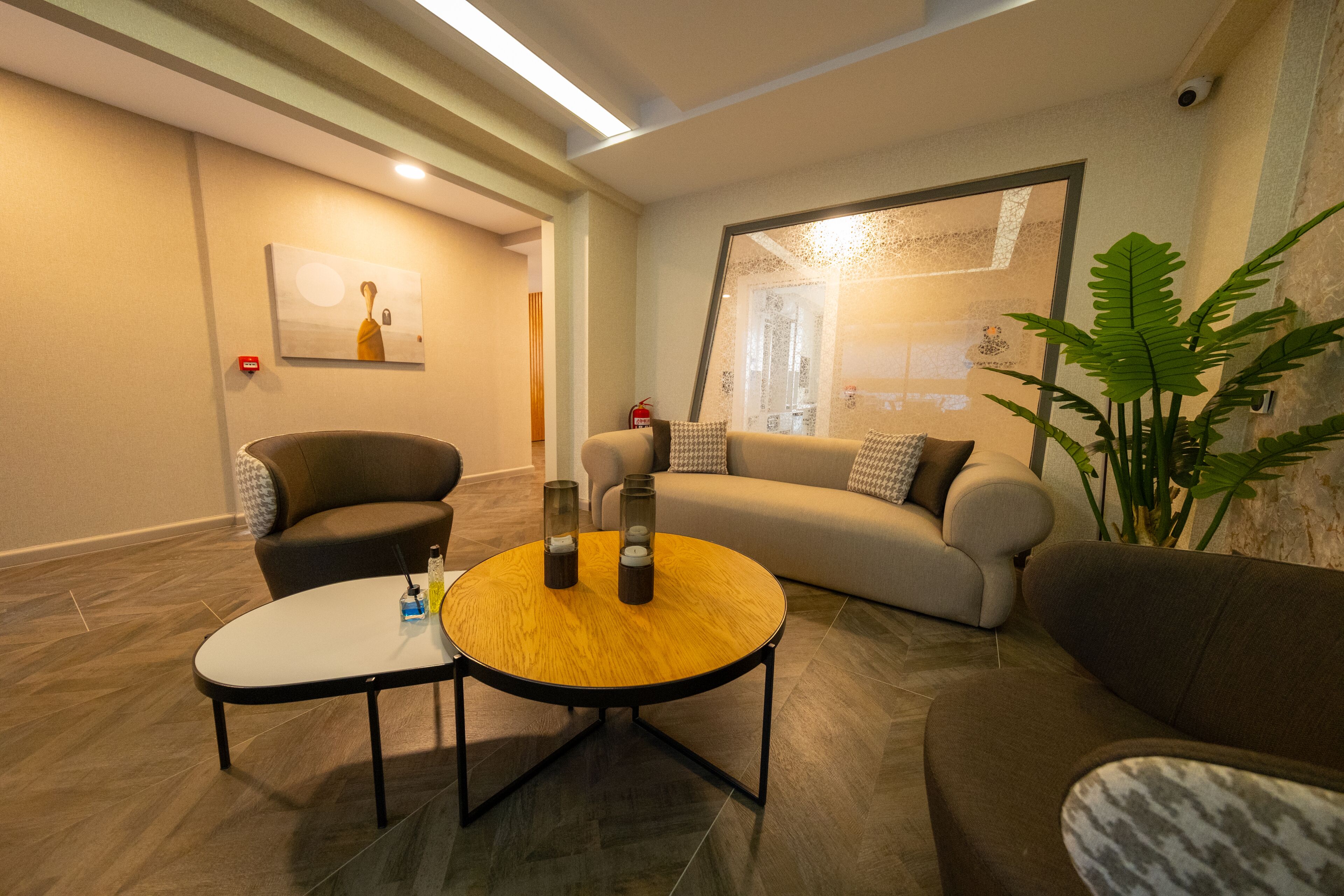 Uma sala de estar moderna com uma mesa de centro redonda de madeira, um sofá e uma poltrona.
