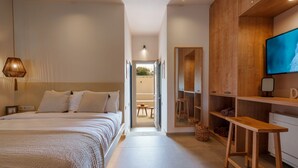 Um quarto moderno com uma cama grande, uma escrivaninha de madeira, uma televisão e vista para o exterior.