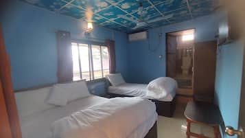 Quarto com duas camas, um ventilador de teto e uma janela com cortinas.