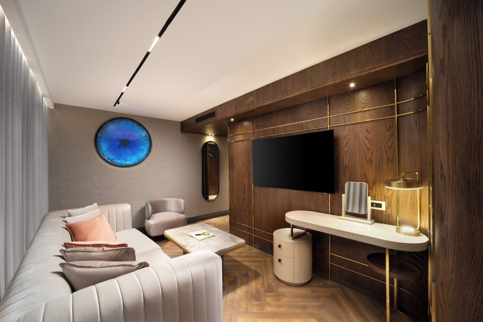 Uma sala de estar moderna com sofá, poltronas, mesa de centro, televisão fixada em uma parede de madeira e uma mesinha de cabeceira com abajur.