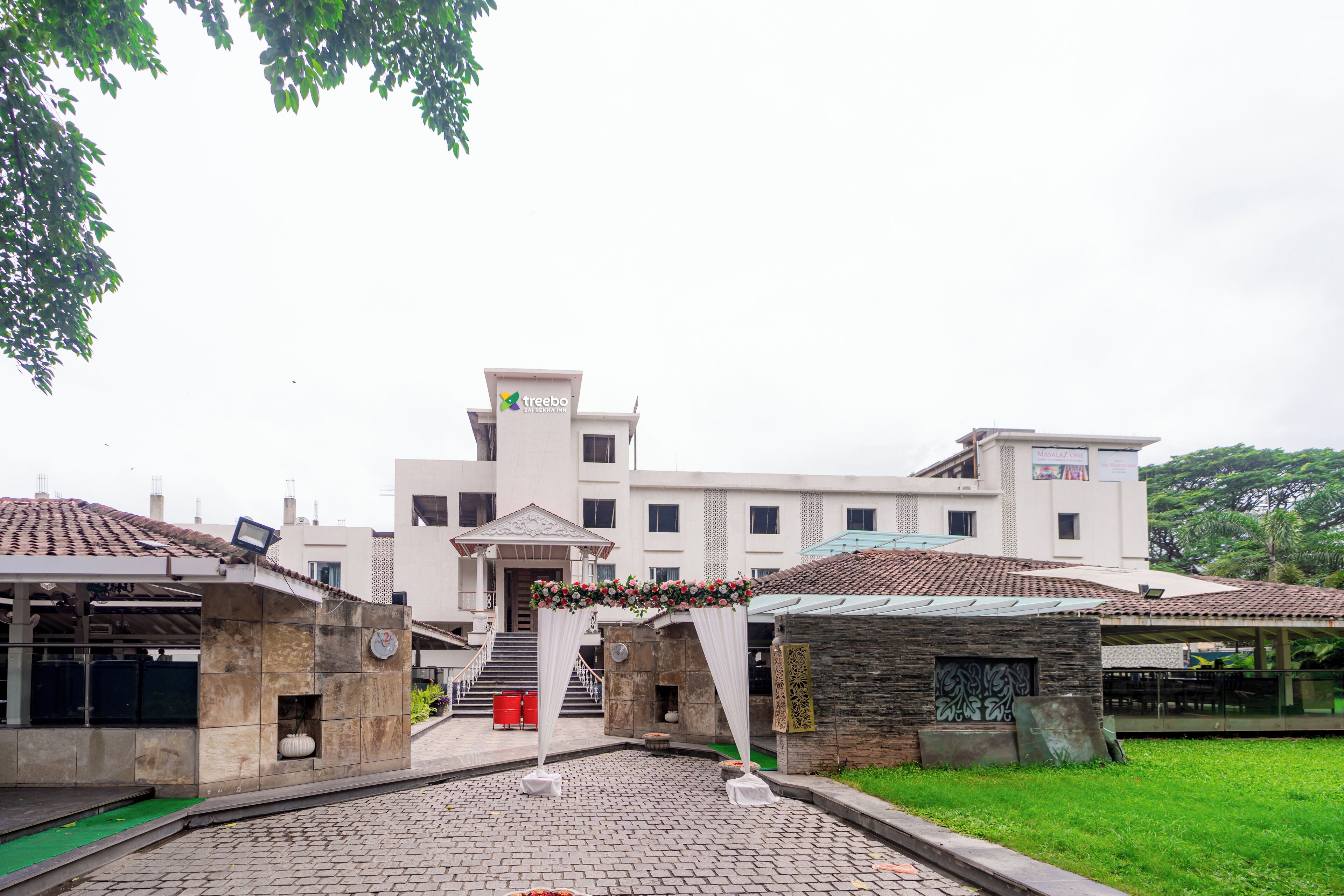 Um edifício com estilo arquitetônico moderno, apresentando uma entrada central com degraus e um arco decorativo.