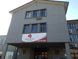 Um edifício com a placa do Hotel Indaba em Sasolburg, exibindo um número de contato.